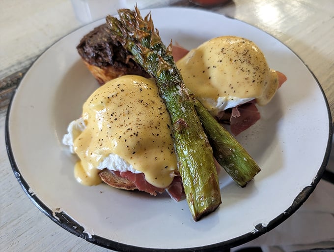 Behold the Rooster Benedict in all its glory—perfectly poached eggs nestled on ham with asparagus standing guard like delicious sentinels.
