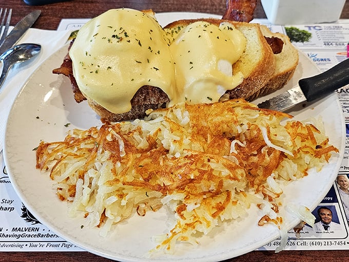 Behold, the star of the show! Two perfectly poached eggs nestled on toast, draped in silky hollandaise with crispy hash browns standing guard.