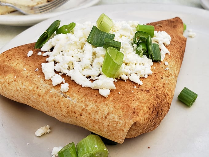 This isn't just a savory pastry – it's a Mediterranean vacation wrapped in dough, topped with feta and green onions.