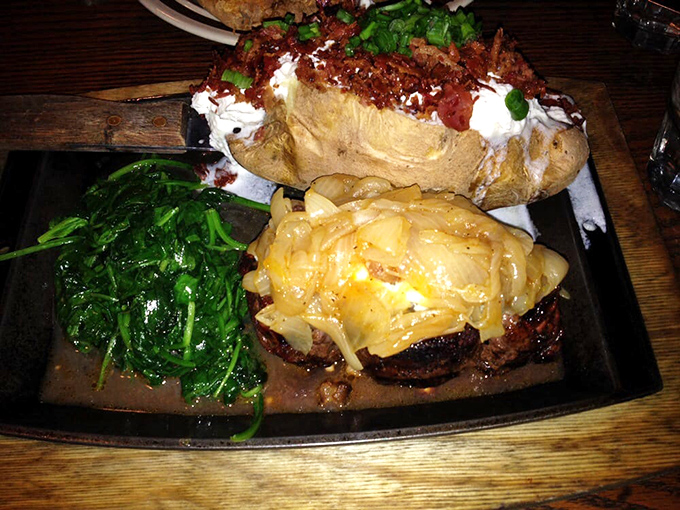 This isn't just dinner—it's edible art. A perfectly seared steak topped with melted cheese alongside a loaded baked potato and fresh greens creates the holy trinity of steakhouse perfection.