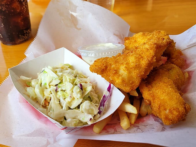 Golden-battered perfection alongside creamy coleslaw. This isn't just fish and chips—it's edible sunshine that crunches.