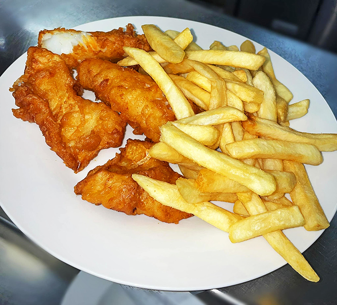 Golden perfection meets crispy satisfaction – this fish and chips plate could make a British pub owner weep with envy.