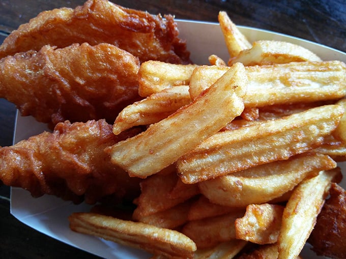 Golden-battered fish nestled against crispy fries—this isn't just fish and chips, it's edible sunshine that crunches between your teeth.
