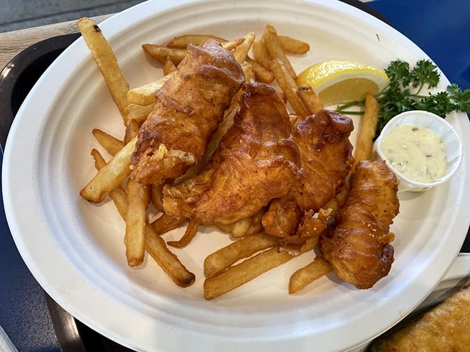 Golden-battered fish that shatters with each bite, revealing pearly white flesh within. This isn't just fish and chips – it's edible poetry.