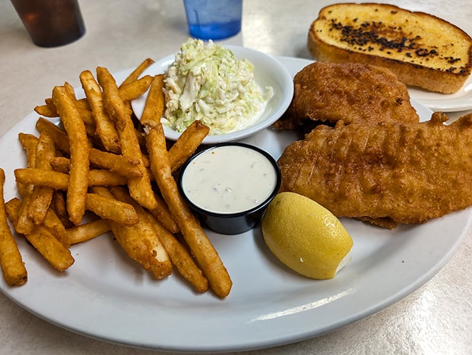 Golden-battered fish with a perfect crunch factor, served alongside crispy fries, coleslaw, and tartar sauce—this is what fish and chips dreams are made of.