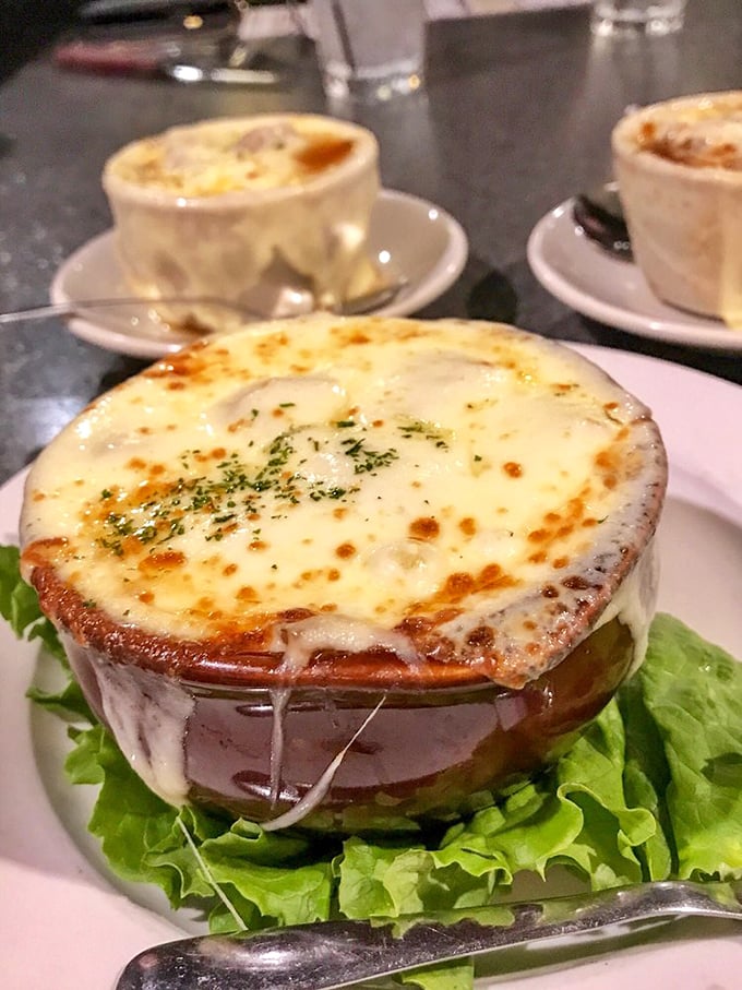 This isn't just French onion soup – it's a bubbling cauldron of cheese stretching to heaven, with a broth so rich it could buy a small country.