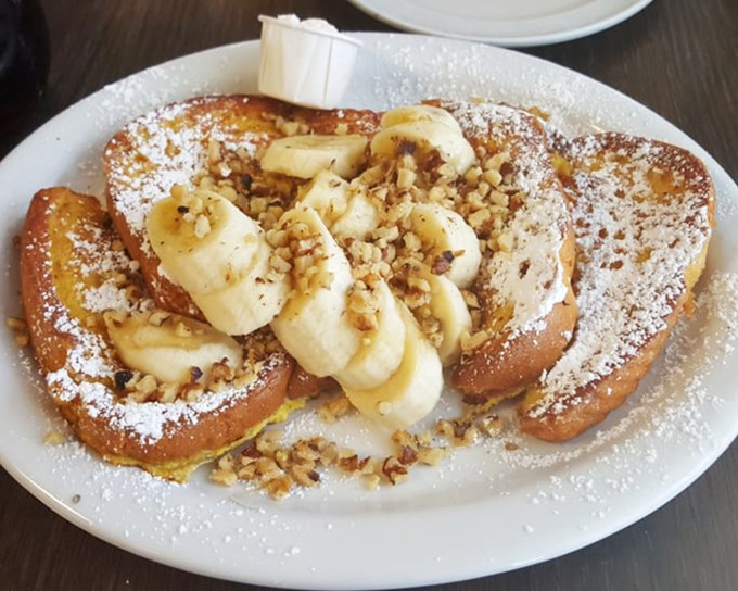 French toast nirvana! Golden slices adorned with bananas, walnuts, and a dusting of powdered sugar—proof that breakfast can indeed be the most important art of the day.