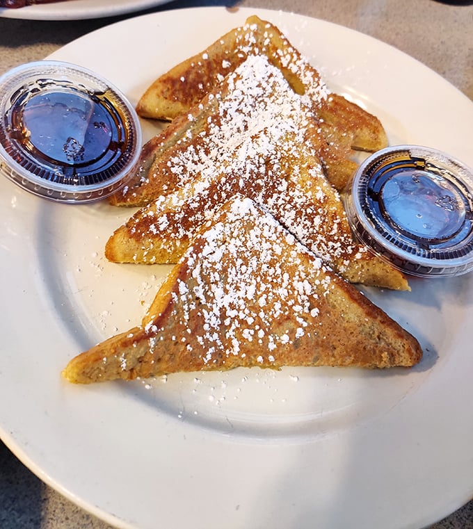 The French toast arrives like a golden revelation—perfectly caramelized triangles dusted with powdered sugar that make you question all other breakfast choices.