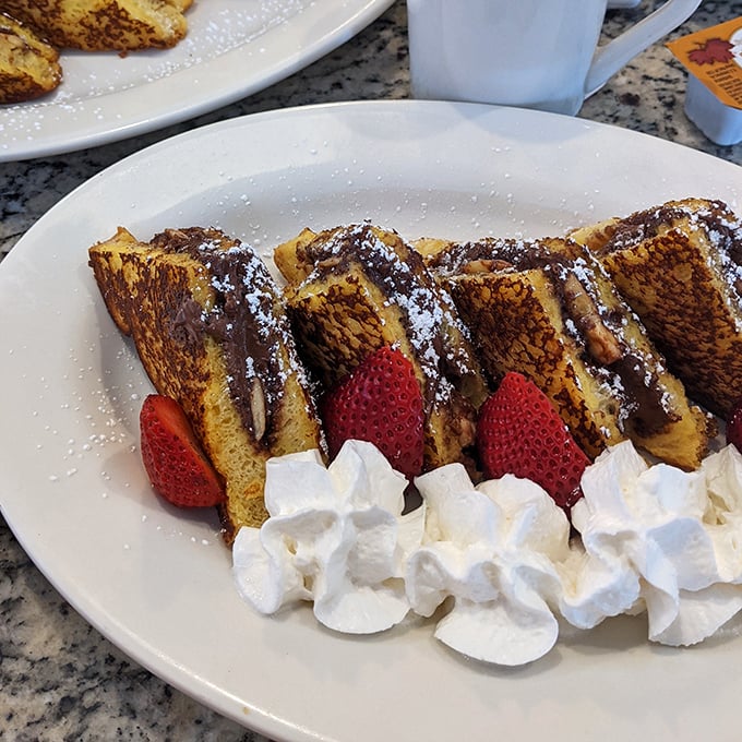 Behold the French toast that launched a thousand morning commutes – powdered sugar falling like sweet snow.