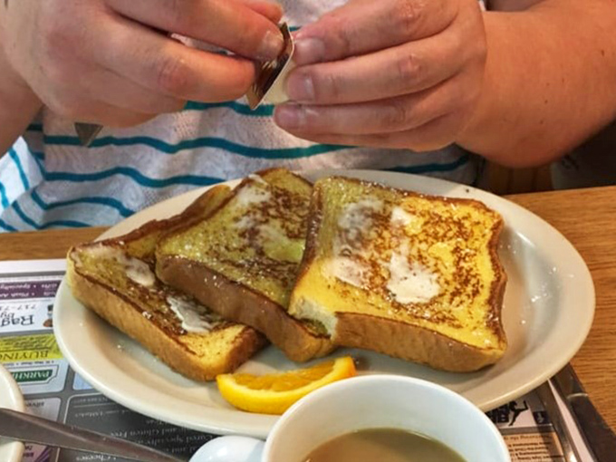 Golden-brown French toast that's achieved that perfect balance – crispy edges, custardy center, and just waiting for that maple syrup waterfall.