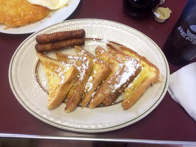 French toast perfection! Golden-brown slices dusted with powdered sugar and served with sausage links – breakfast doesn't get more beautiful than this.