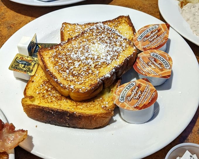 Golden-brown French toast dusted with powdered sugar—the breakfast masterpiece that launched a thousand road trips. Worth setting your alarm for.