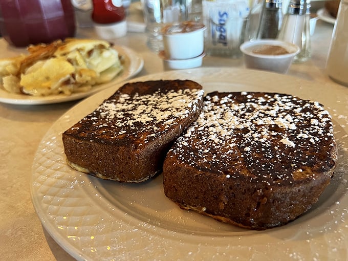 This French toast doesn't just arrive at your table – it makes an entrance, dusted with powdered sugar like fresh snow on Christmas morning. 