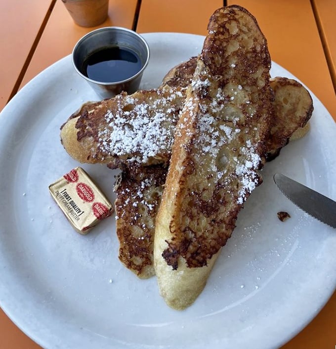 Behold the French toast that launches a thousand road trips – thick, golden, and dusted with powdered sugar perfection.