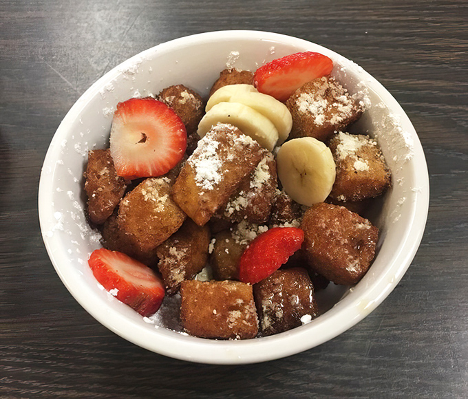 These French toast bites aren't just breakfast—they're little cubes of joy dusted with powdered sugar and crowned with fresh fruit.