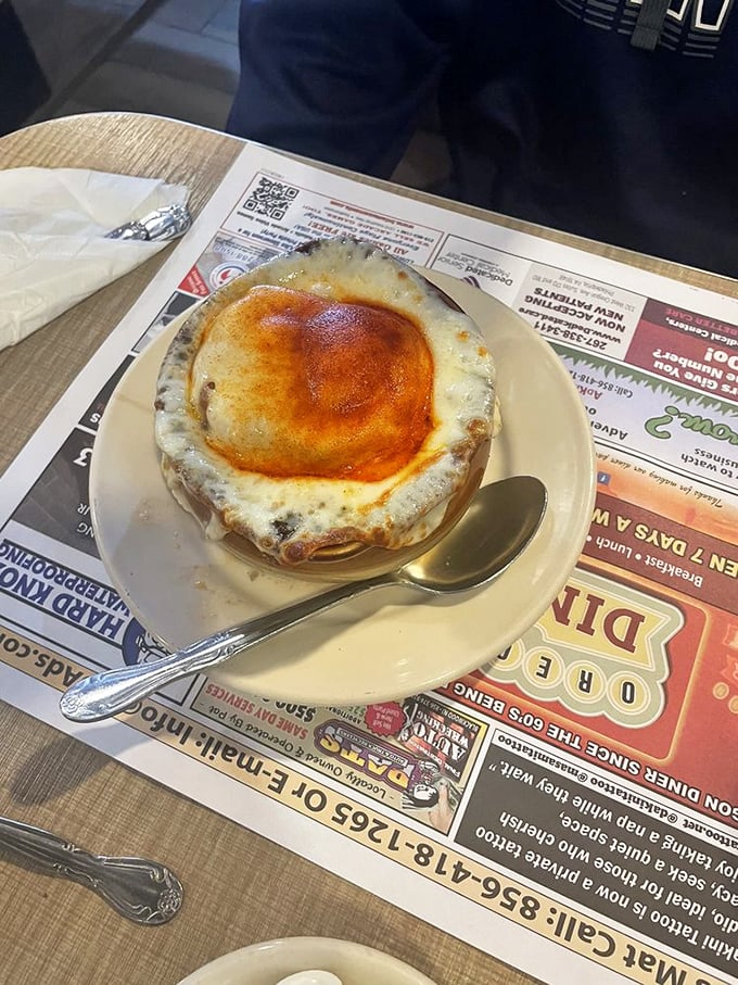 Behold the French onion soup in all its glory—a bubbling cauldron of savory broth beneath a golden cheese canopy. Spoon-stretching perfection!
