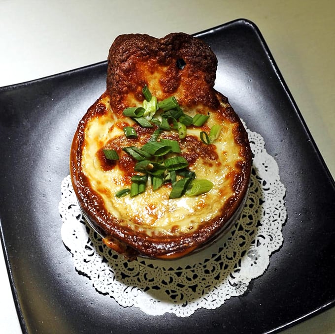 Behold the French onion soup that's worth the pilgrimage – bubbling cheese heaven in a ceramic crock.