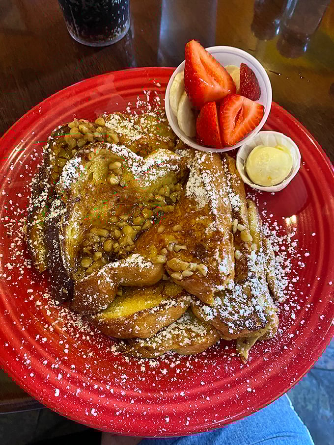 This isn't just French toast – it's a morning masterpiece dusted with powdered sugar, topped with walnuts, and accompanied by nature's candy: fresh strawberries.
