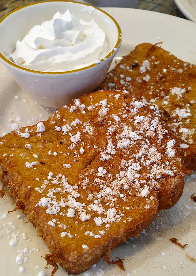 Golden-brown French toast dusted with powdered sugar – this isn't breakfast, it's edible sunshine that makes you forget you're an adult with responsibilities.