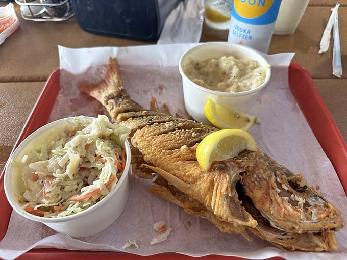 The whole fried snapper doesn't just look at you—it winks! Crispy, golden perfection with coleslaw that's actually worth eating.