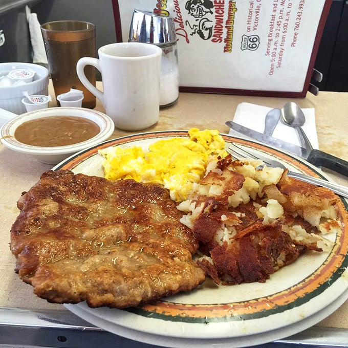Country-fried steak that doesn't just hang over the edge of the plate—it practically declares manifest destiny across your breakfast territory.