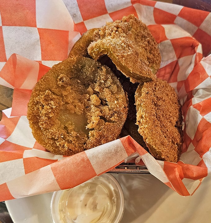 Golden-brown discs of tangy perfection nestled in a red-checkered basket. These fried green tomatoes aren't just appetizers—they're edible Southern history.