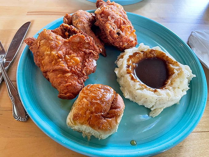 Golden-brown fried chicken that shatters with each bite, paired with mashed potatoes sporting a gravy lake deep enough to dive into.