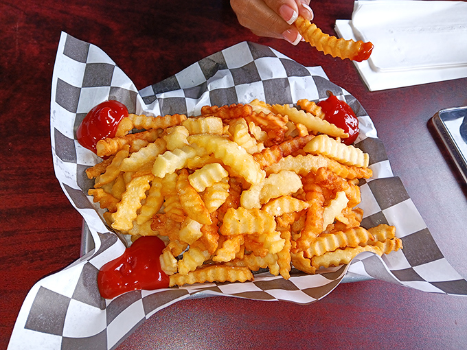 These aren't just fries—they're crinkle-cut works of art that somehow maintain their structural integrity from first dip to last bite.