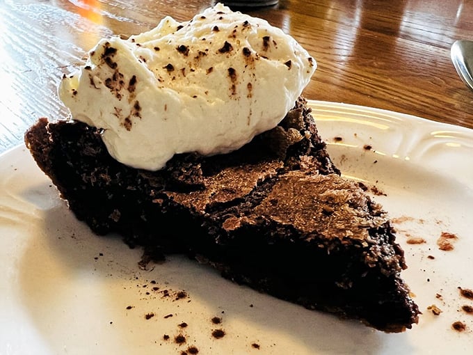 The legendary fudge pie—a chocolate revelation with that perfect crackly top and cloud of whiskey-kissed whipped cream. Worth every mile of the drive.