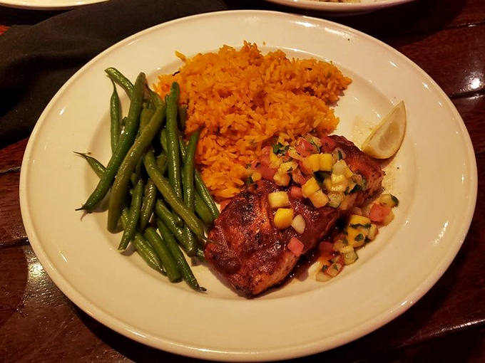 Not just salmon, but a revelation on a plate—perfectly glazed, nestled beside vibrant green beans and orange rice that tastes like sunshine decided to become a side dish.