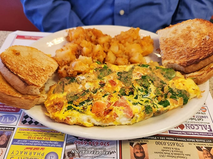 This isn't just any omelet—it's a masterclass in breakfast architecture with perfectly golden edges and a garden of vegetables tucked inside.