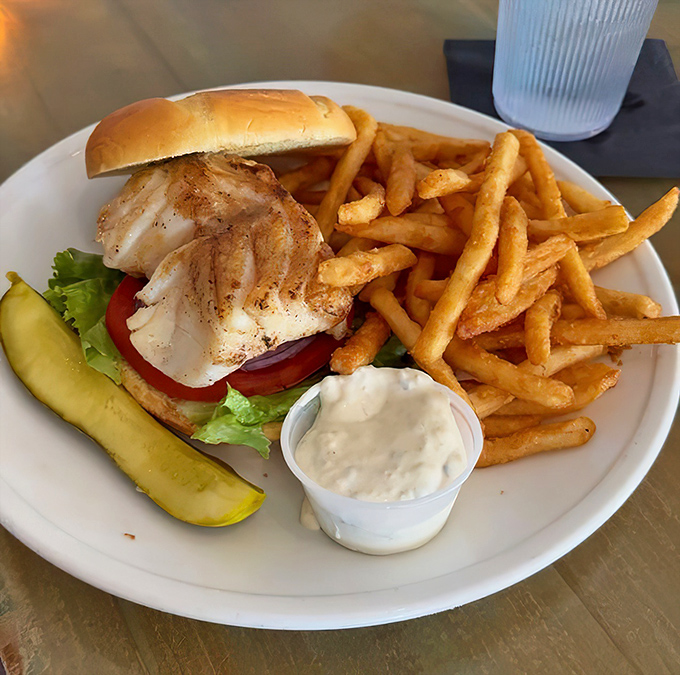 This blackened grouper sandwich isn't just lunch—it's a Florida rite of passage, served with a pickle spear standing at attention like it knows it's in the presence of greatness.