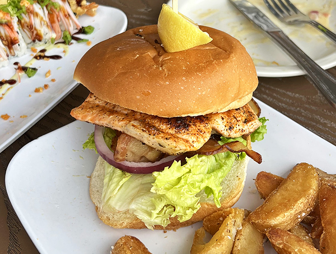 Behold the star of the show—a grouper sandwich that makes other fish sandwiches look like they're not even trying. That lemon wedge isn't garnish, it's essential equipment.