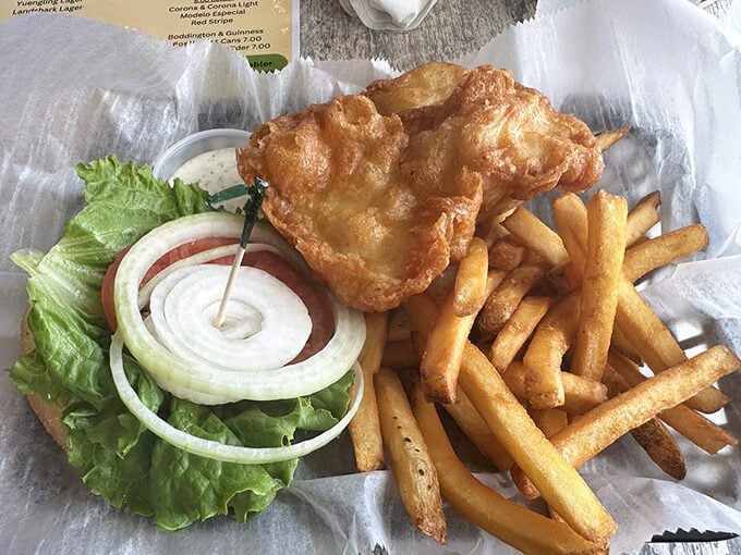 The legendary grouper sandwich in its natural habitat – golden-battered perfection nestled alongside crispy fries. Worth every mile of the drive.