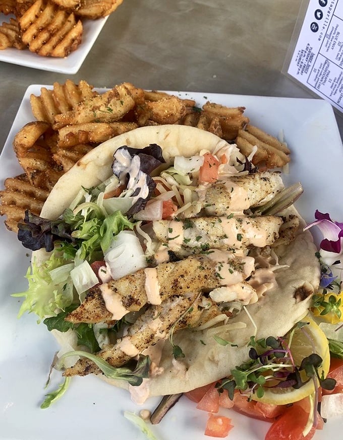 Behold the headliner: grouper tacos with crispy waffle fries. That perfect flake, the fresh toppings, the hint of sriracha lime crema—this is why people drive across state lines for lunch.
