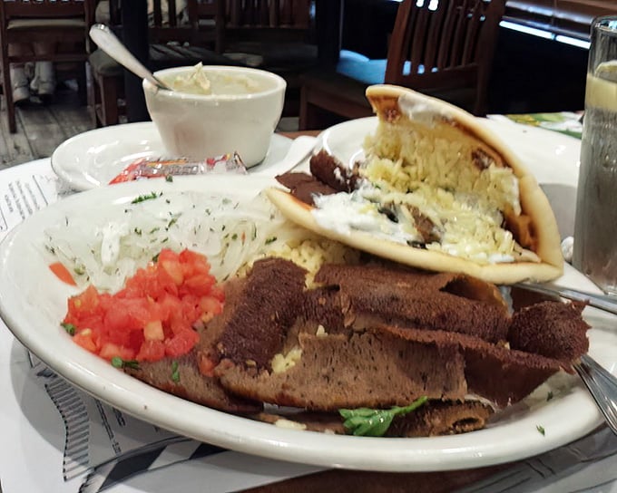 Behold the gyro in its natural habitat—seasoned meat, fresh veggies, and tzatziki sauce creating that perfect harmony worth driving to Surprise for.