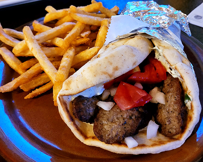 This gyro isn't just a sandwich—it's a masterpiece of seasoned meat, fresh veggies, and tzatziki sauce that demands a two-handed commitment.