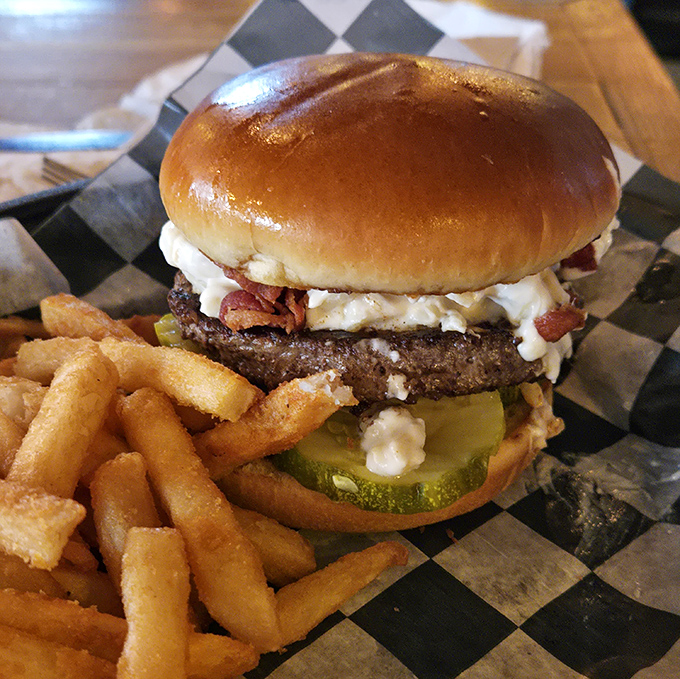 Behold, burger perfection: a golden-brown bun cradling a juicy patty topped with what appears to be bacon and cheese—proof that sometimes the simplest pleasures are the most profound. 