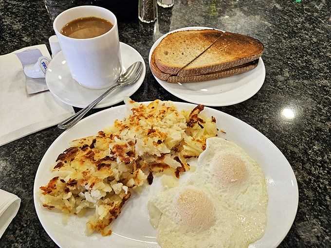 Perfectly crispy home fries sharing a plate with sunny-side up eggs—a breakfast duet performing the morning's most satisfying symphony.