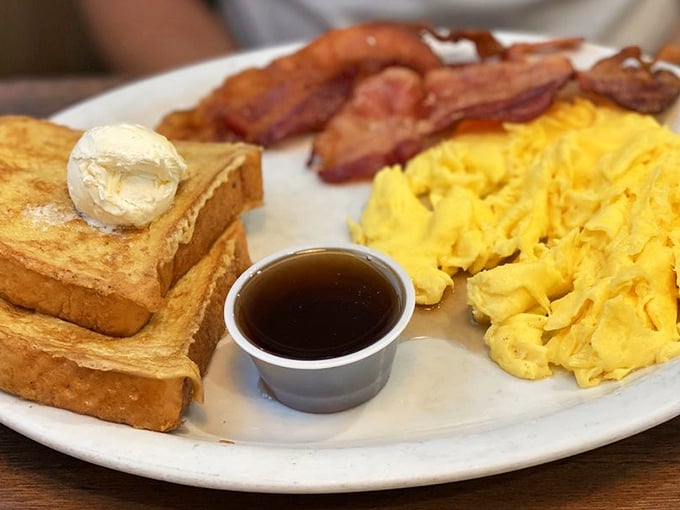 The breakfast trinity: perfectly golden toast, scrambled eggs that defy physics with their fluffiness, and bacon cooked to that magical sweet spot.