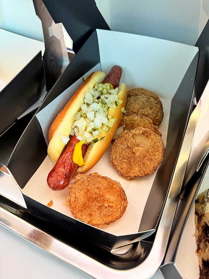 This isn't your average ballpark frank – it's a gourmet hot dog nestled in a perfect bun with crispy hash brown bites standing guard.