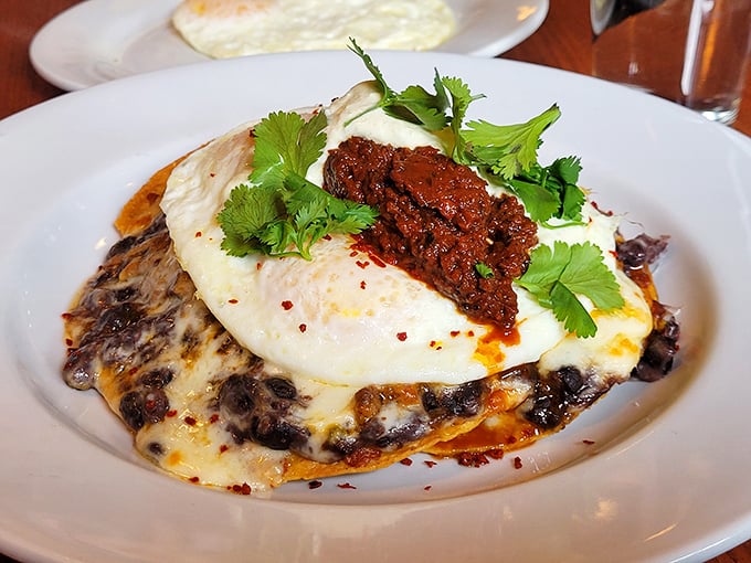 Huevos rancheros reimagined with a Southern twist—where eggs meet black beans under a blanket of melted cheese and that spicy topping that makes taste buds dance.