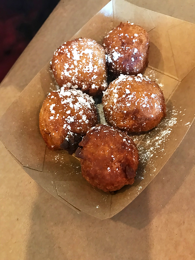 Golden-brown hush puppies dusted with powdered sugar—a sweet-savory contradiction that somehow makes perfect sense, like finding WiFi on a deserted island.