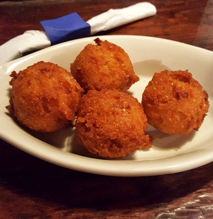 Golden orbs of cornmeal perfection that might make you forget your table manners. These hush puppies aren't just side dishes—they're the main event.