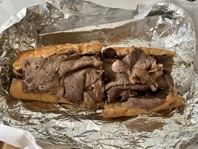 Behold the Italian beef in all its glory—thinly sliced, perfectly seasoned, and nestled in bread that somehow remains structurally sound despite its juicy baptism.