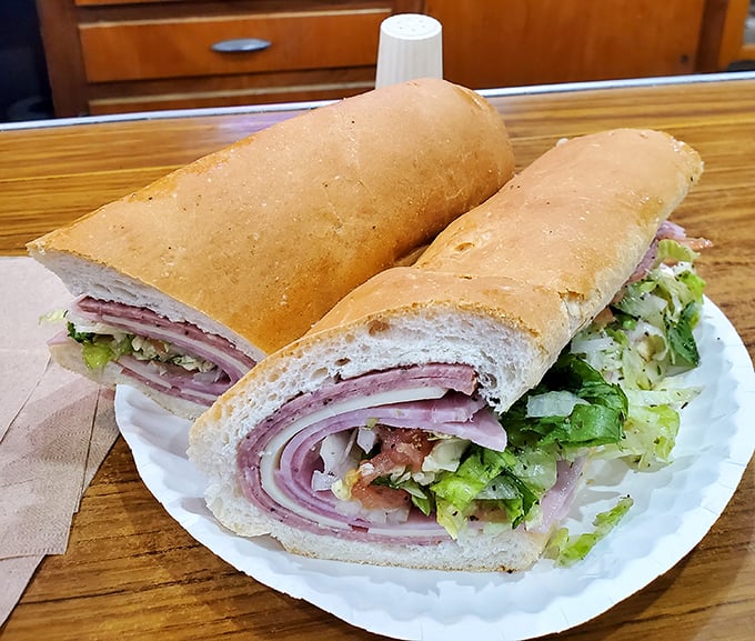 Behold the Italian hoagie in all its glory—layers of meat and veggies stacked with architectural precision that would make Frank Lloyd Wright weep with joy.