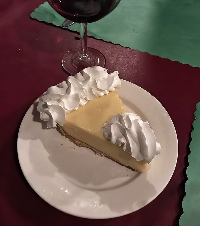 The legendary Key lime pie arrives with perfect proportions—tangy custard balanced by a cloud of whipped cream atop a graham cracker foundation.