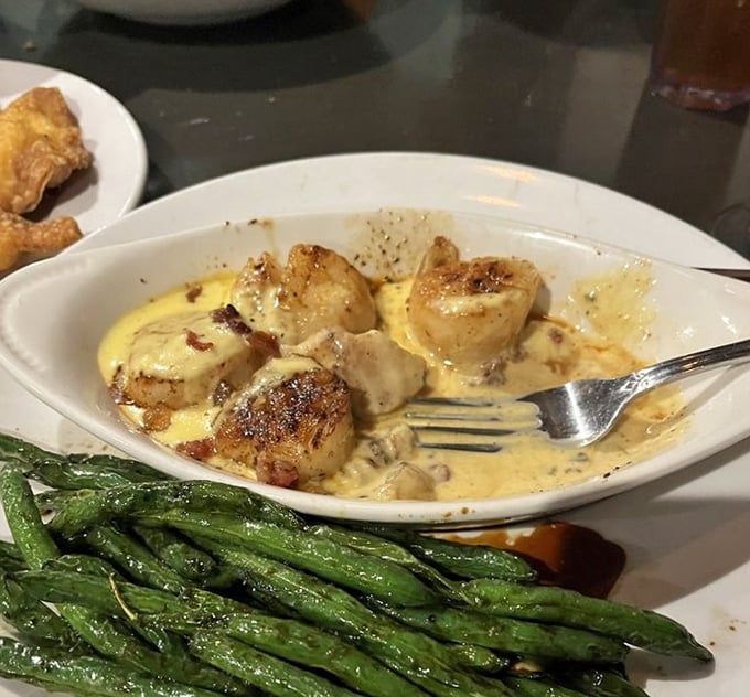 These scallops aren't just cooked—they're transformed into buttery golden treasures swimming in a sauce you'll want to bottle and take home.