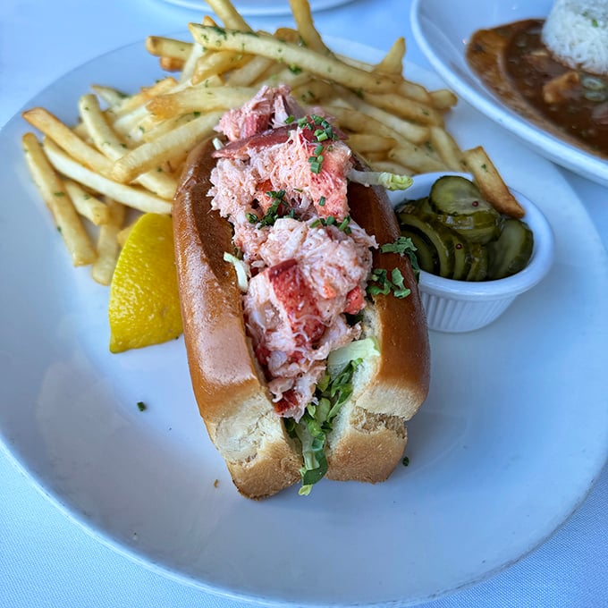Behold the lobster roll that launched a thousand return visits – pure Maine-style perfection nestled in buttery bread bliss.