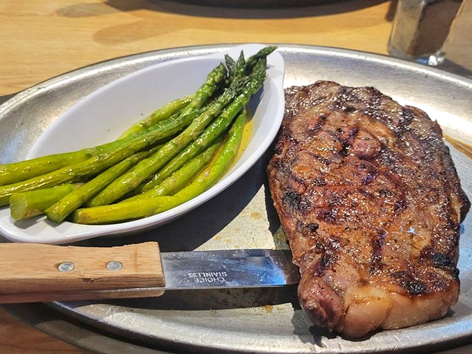 The star of the show: a perfectly seared ribeye alongside bright asparagus. This isn't just dinner—it's Michigan's answer to carnivorous prayers.